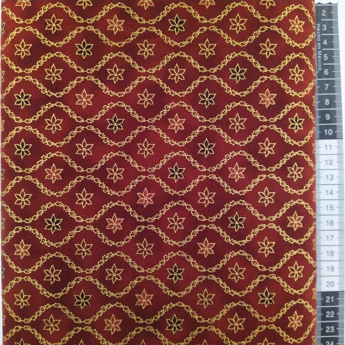 Patchwork stof, rød meleret med guld stjerner og guirlander. – skerping